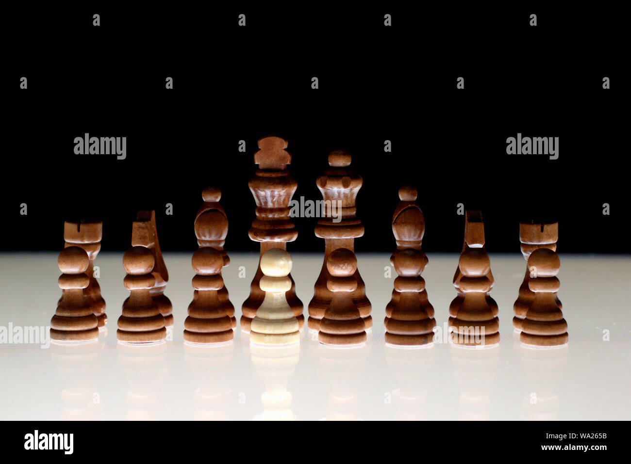 Black chess formation with a single white piece as a concept for ...