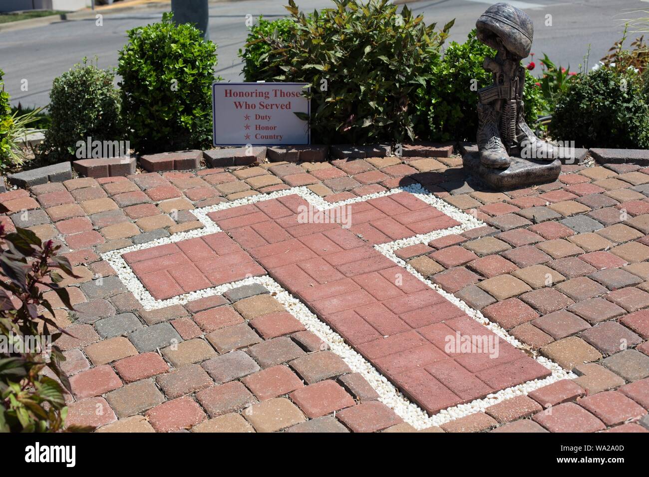 A cross made of bricks, and a sculpture of boots and helmet at the ...