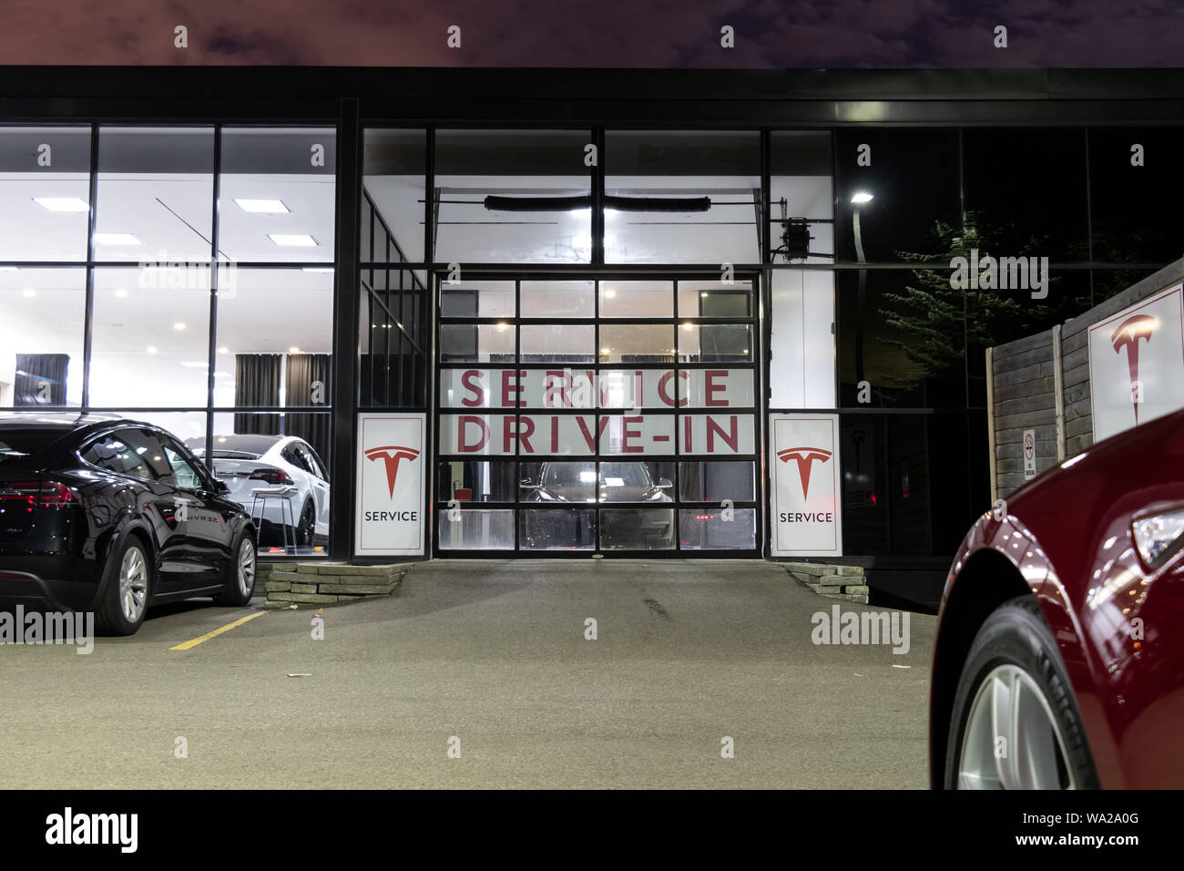 Entrance of Tesla Service Center Drive-In at night with Tesla Model 3 ...