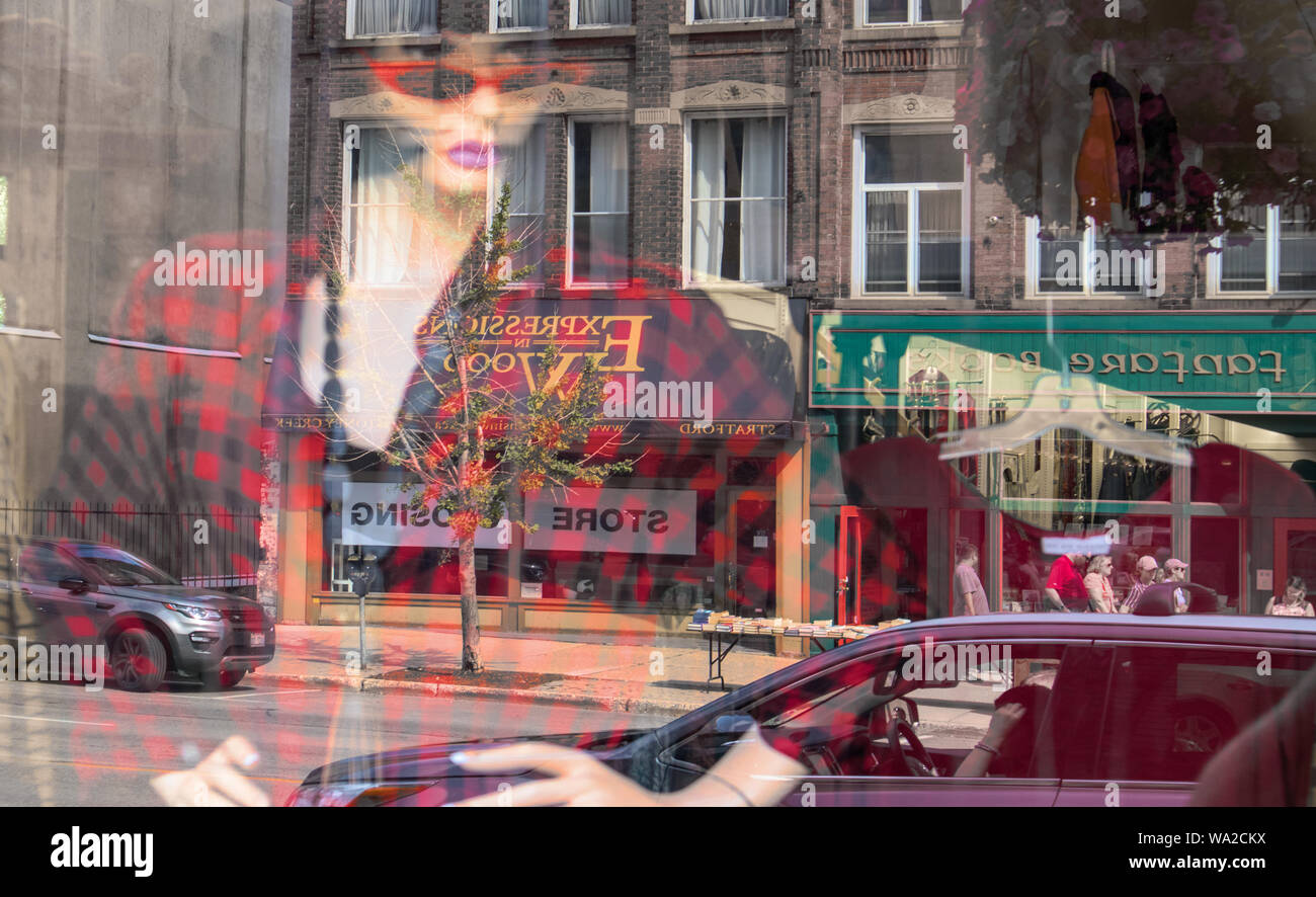 We see models, (dummies) through a shop window. At the same time, the ...