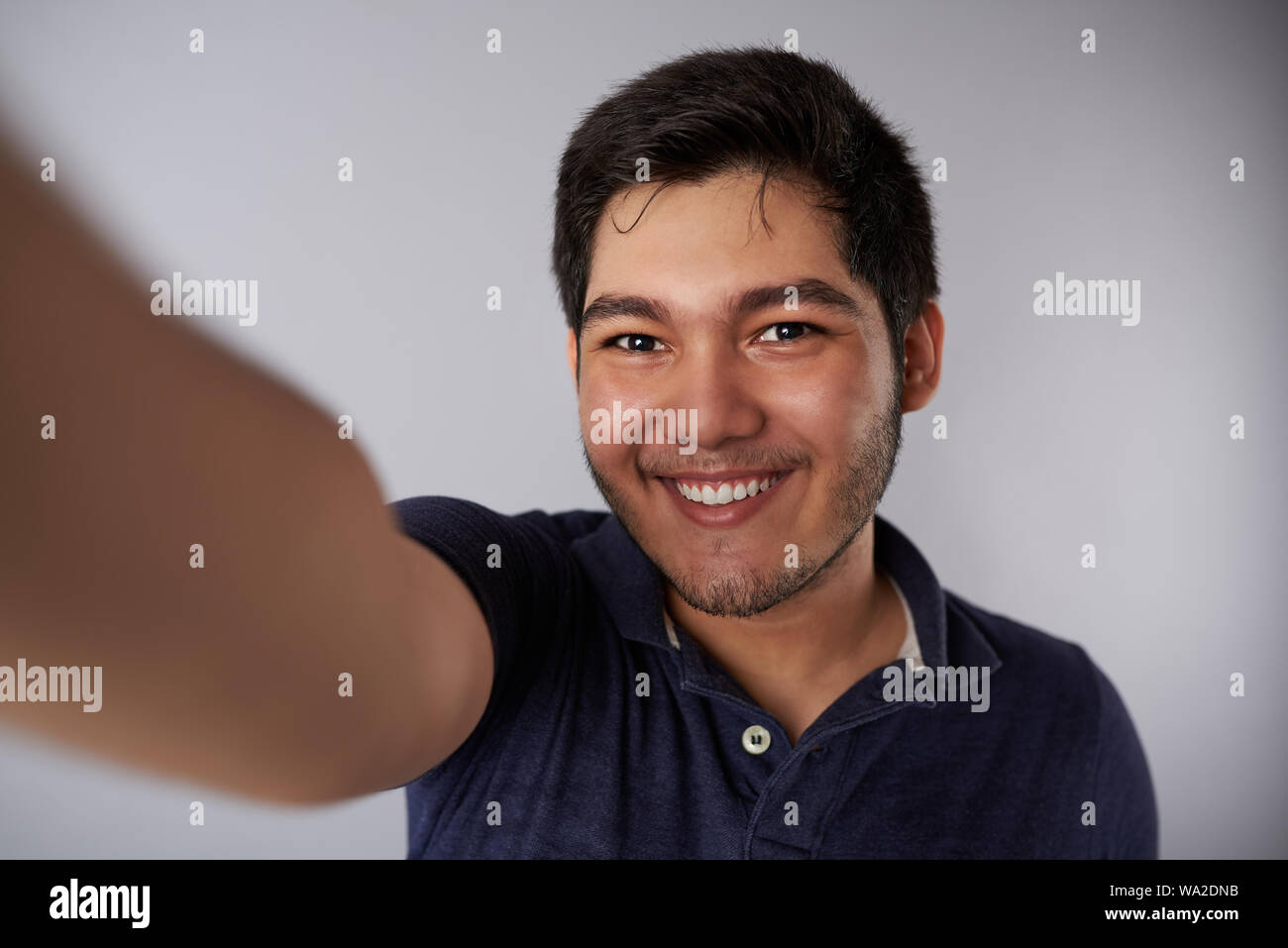 Smiling man taking selfie isolated on gray studio background Stock ...
