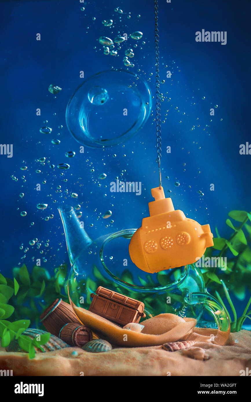 Teapot with a yellow submarine tea strainer. Underwater photography ...
