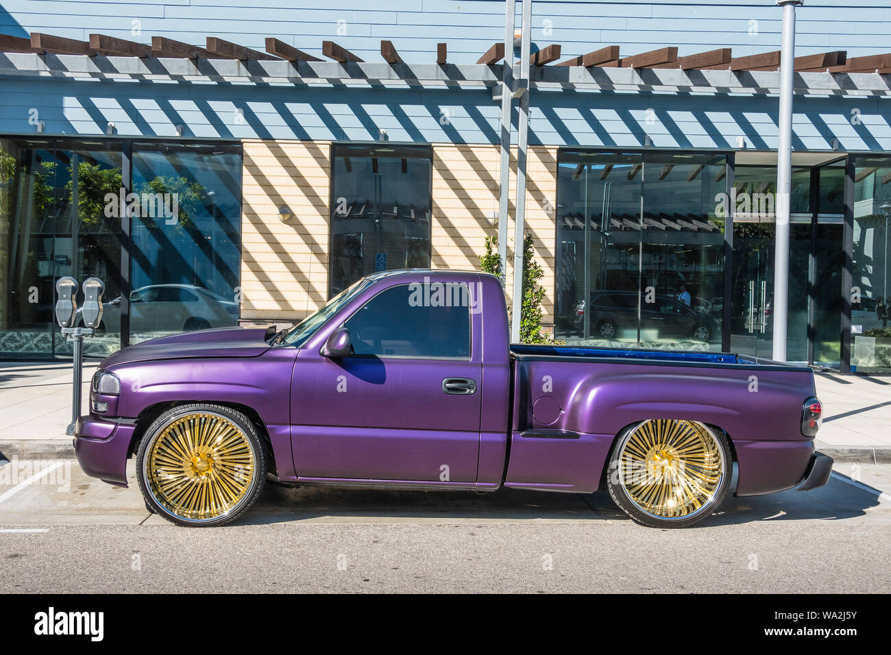 A customized two-door pickup truck with metallic purple paint and fancy ...