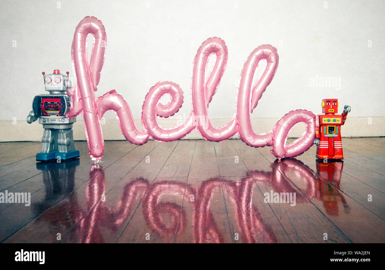 retro robot holding up a pink hello balloon with reflection Stock Photo ...