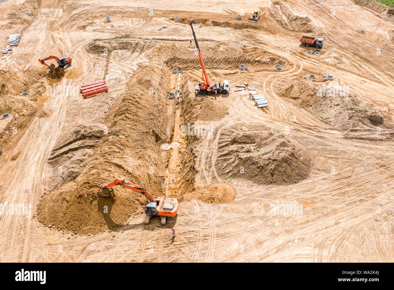 aerial top view of industrial machinery laying pipes for underground ...