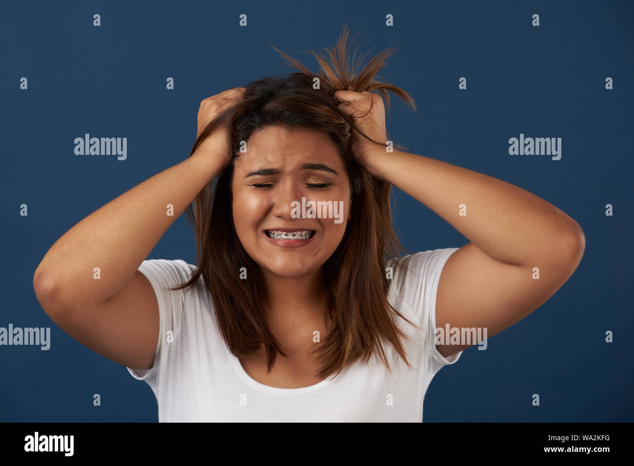 Upset young woman portrait isolated on blue studio background Stock ...