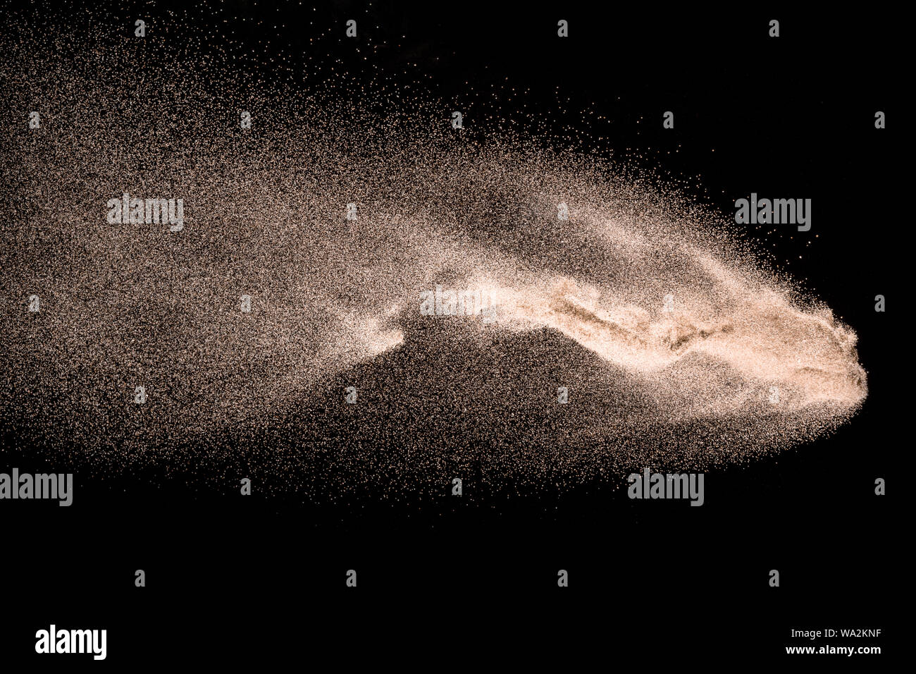 Dry river sand explosion. Golden colored sand splash against black ...