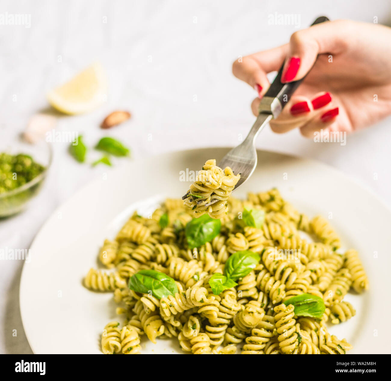 Eating pasta with basil and cheese pesto against white background Stock ...