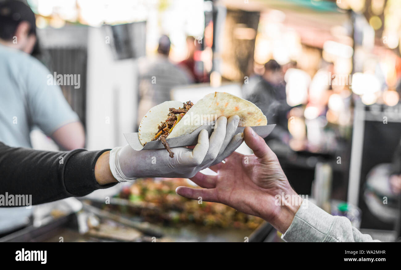 Chef handing a taco to a foodie at a street food market Stock Photo - Alamy