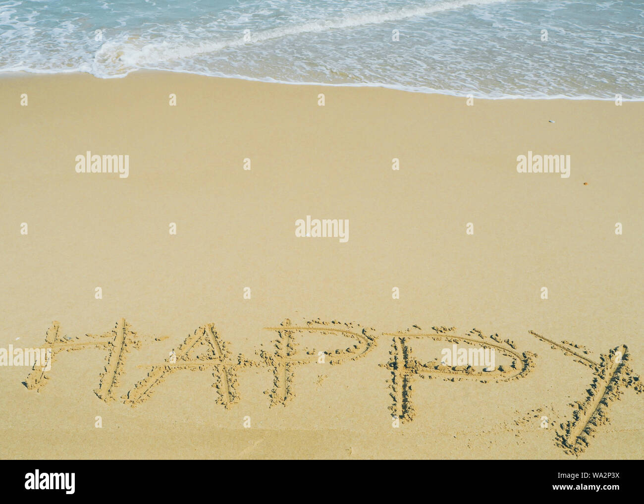 Happy wording written on sand next the sea. relaxing and enjoying ...