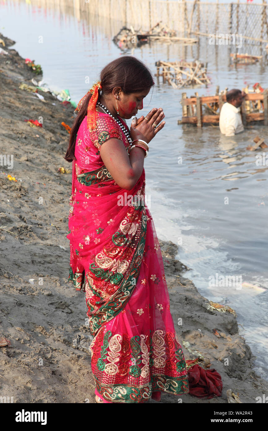 Woman praying at river Stock Photo - Alamy