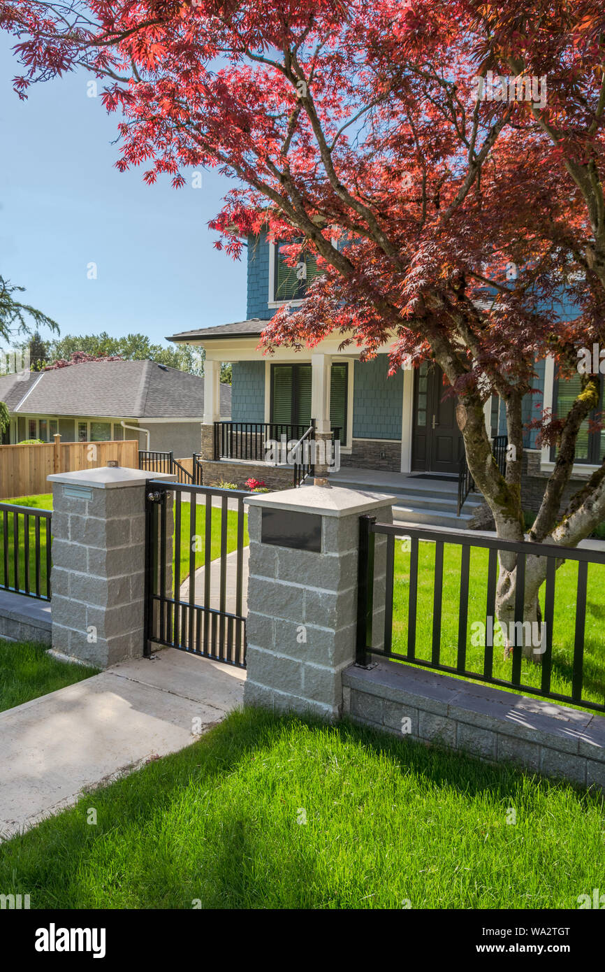 Concrete pathway and metal gate in front of residential house Stock ...
