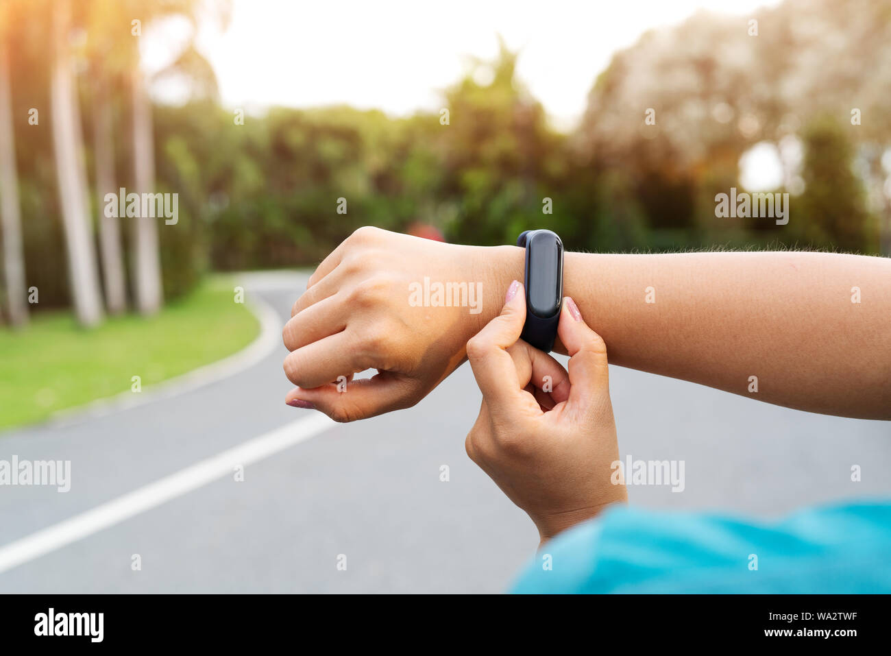 fitness woman runner setting up smart watch before running. Outdoor ...