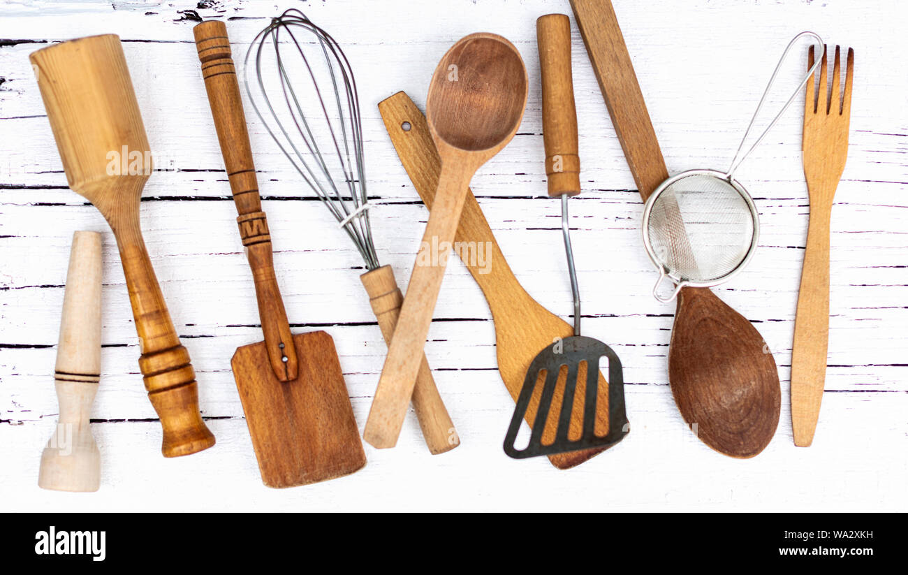 Vintage old kitchen utensils on a white wooden background. Selective ...