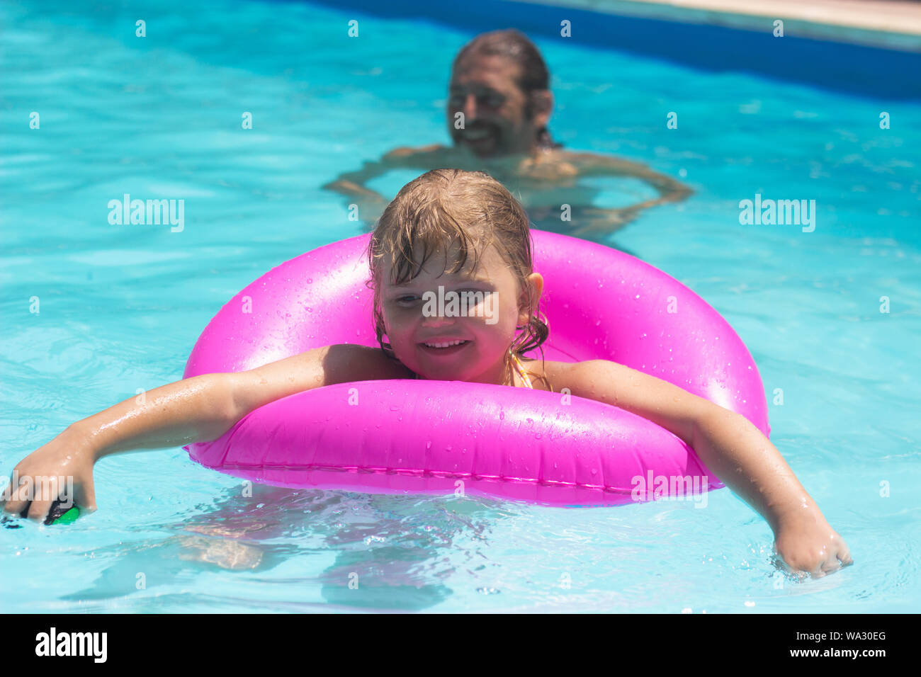 Cute little girl with swim ring, enjoys the pool with her fahter Stock ...