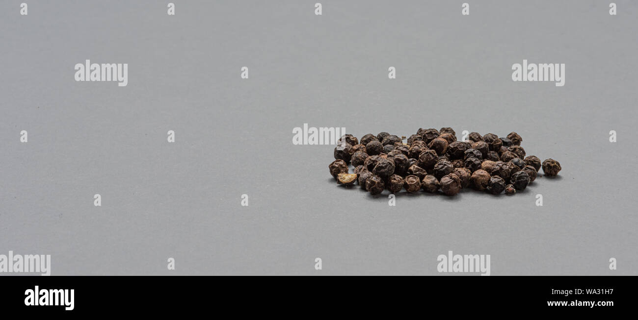 Black pepper on grey background Stock Photo - Alamy