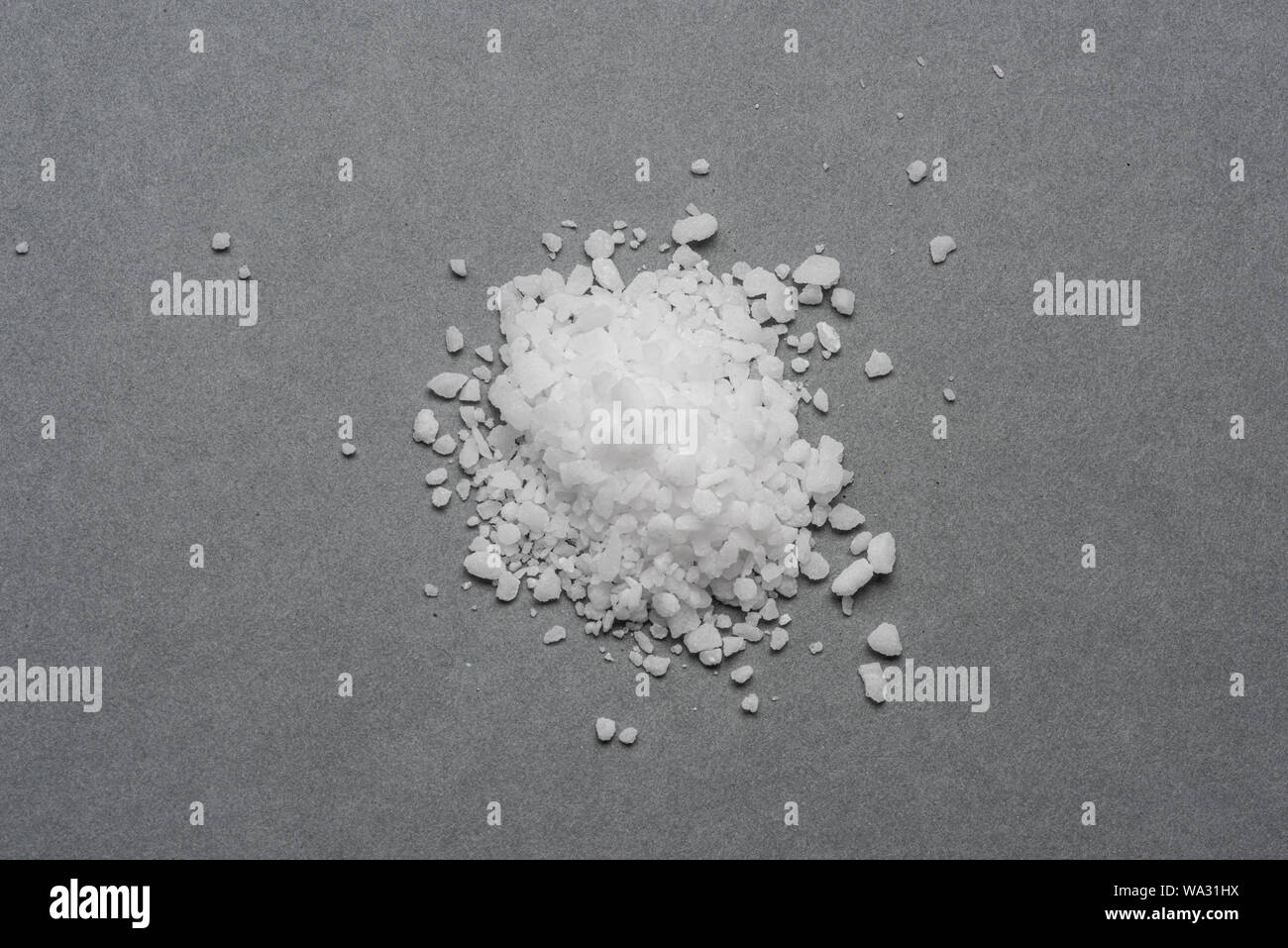 Small pile of salt crystals on grey background Stock Photo - Alamy