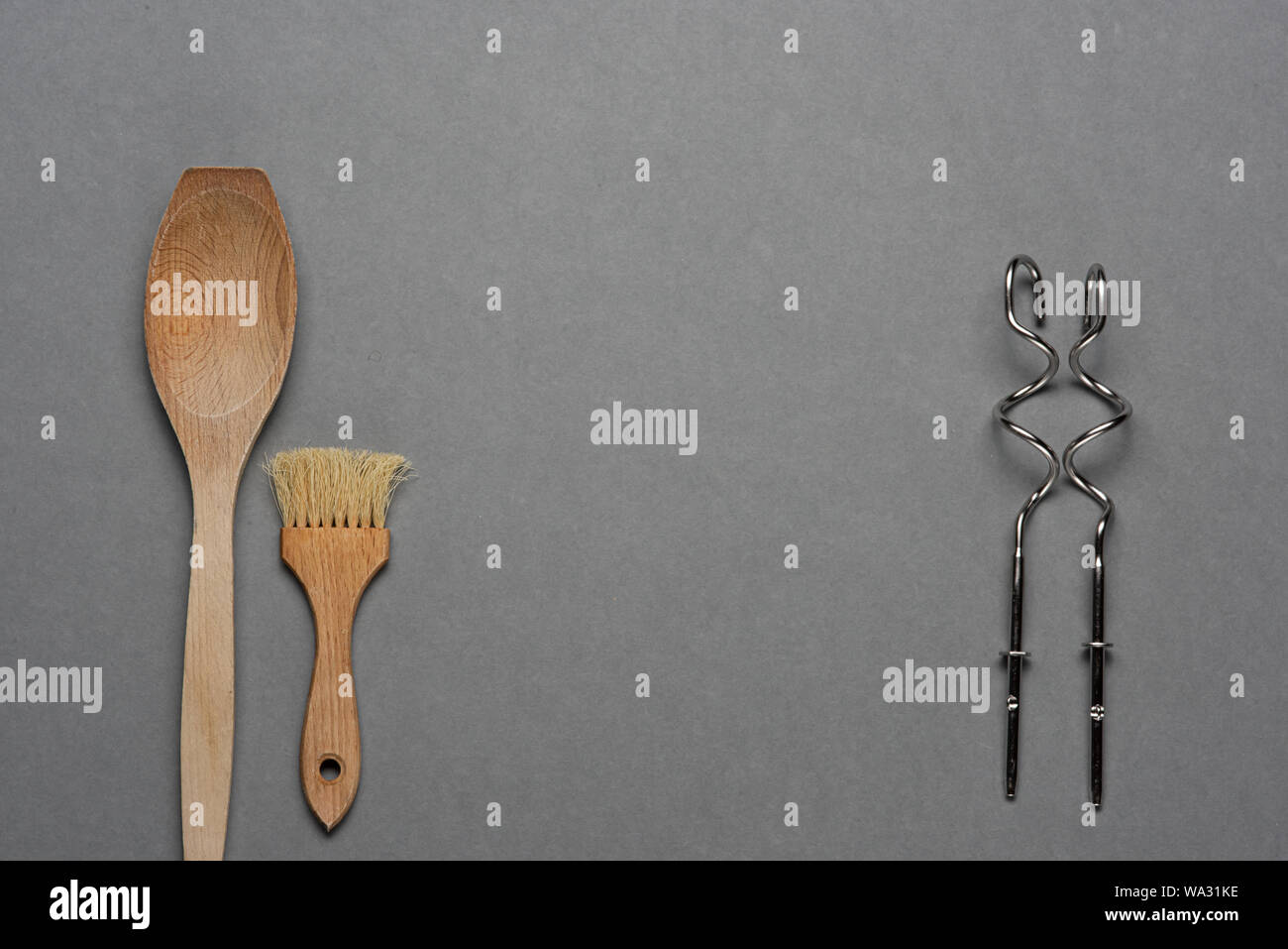 Wooden spoon and kneading hooks on grey background Stock Photo - Alamy