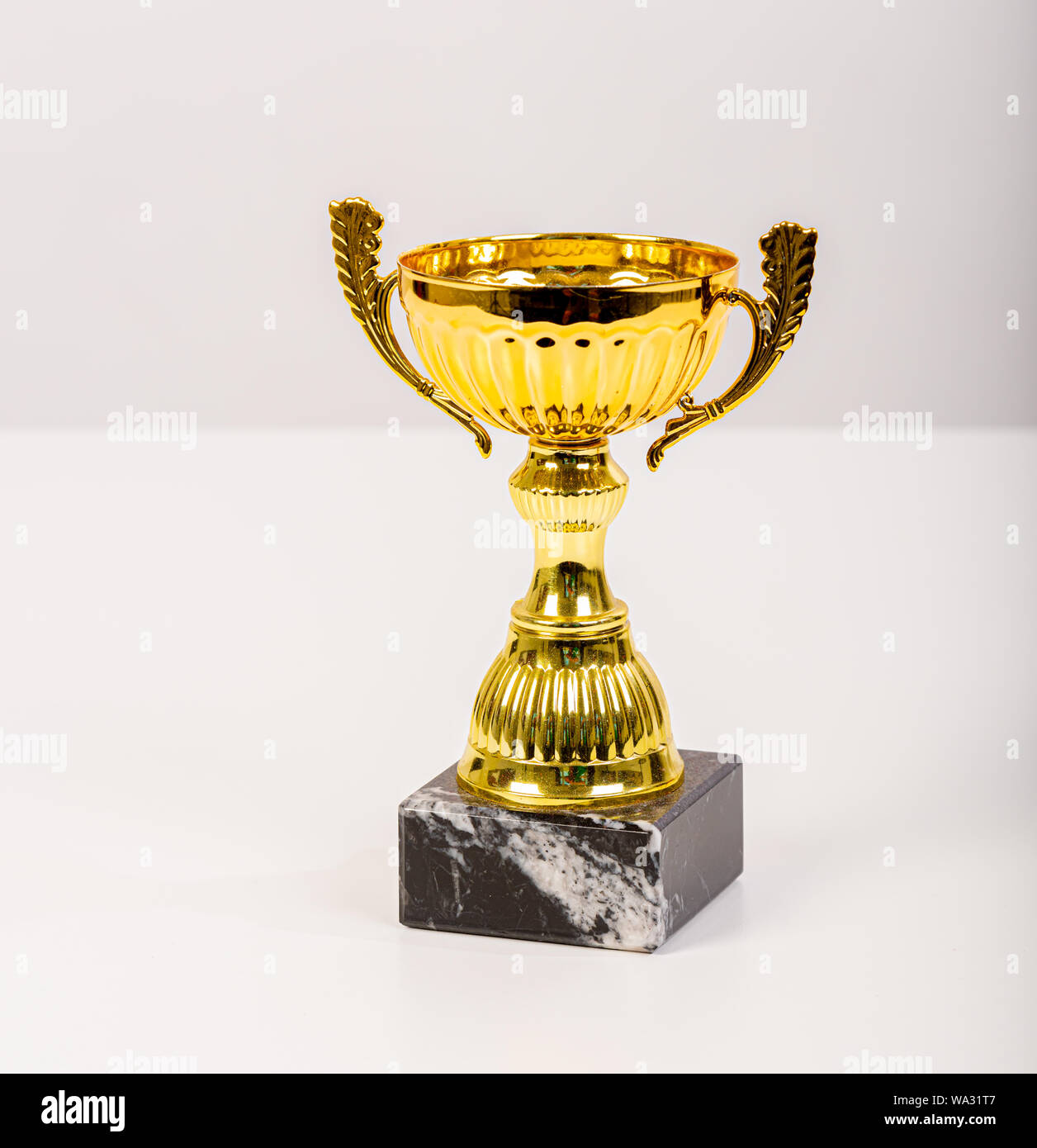Gold trophy with marble base on light grey background Stock Photo - Alamy