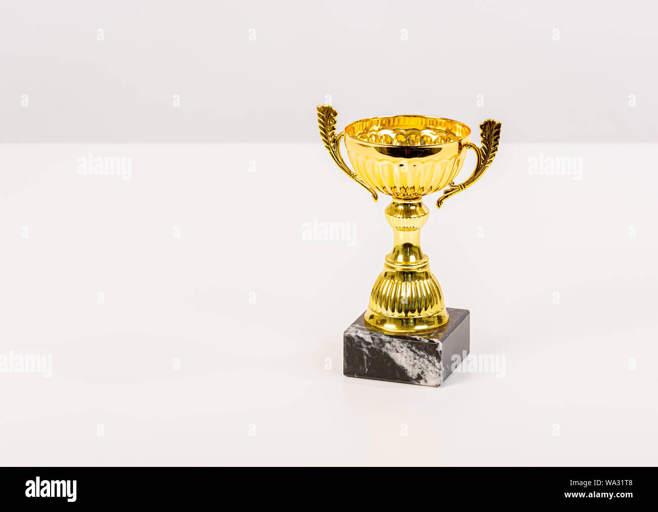 Gold trophy with marble base on light grey background Stock Photo - Alamy