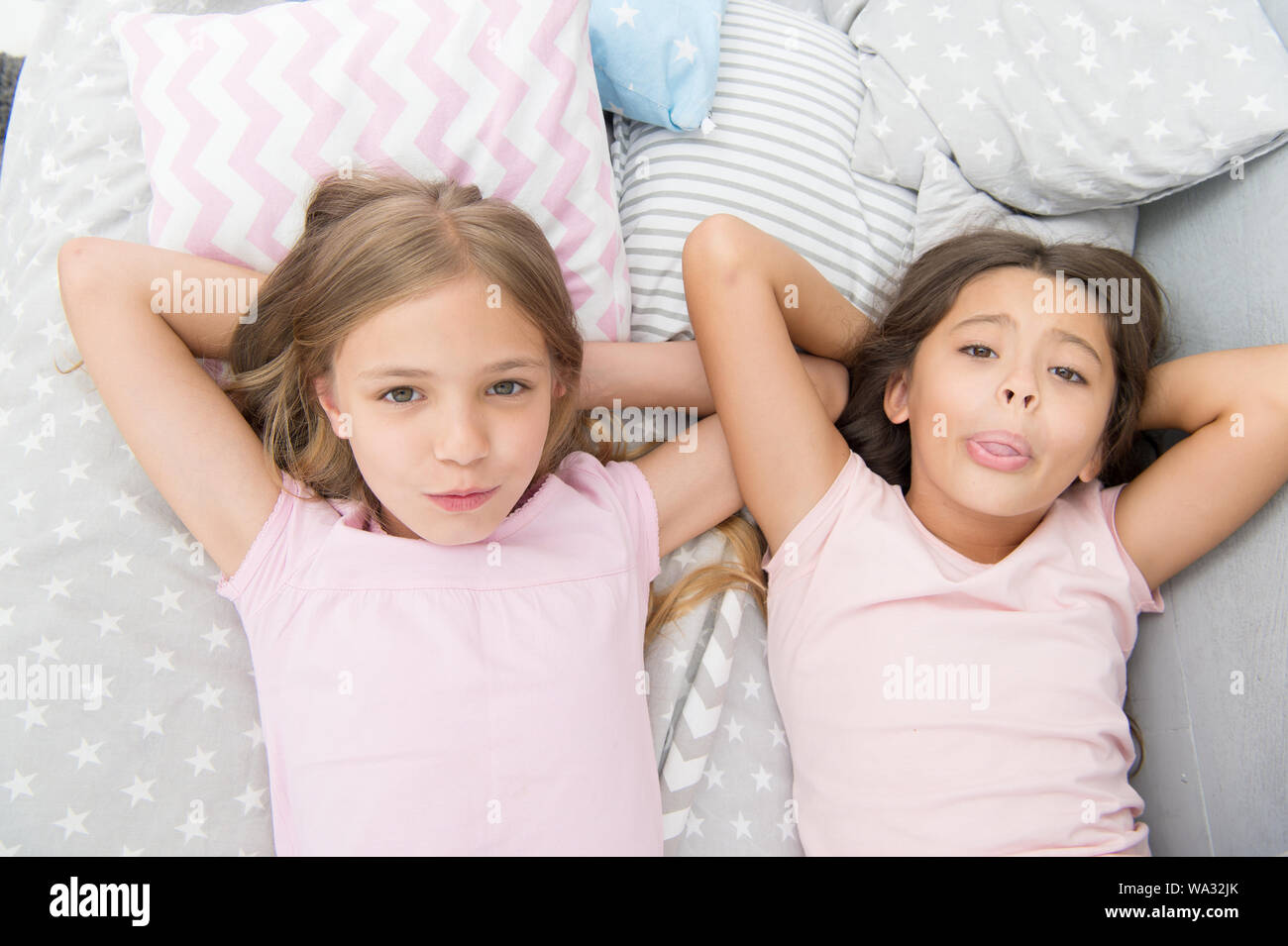 Sisterhood concept. Sharing secrets. Kids relaxing on bed. Sisters ...