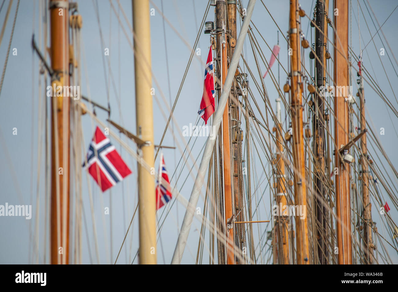 Norwegian flags hanging from the masts of old wooden sailing boats ...
