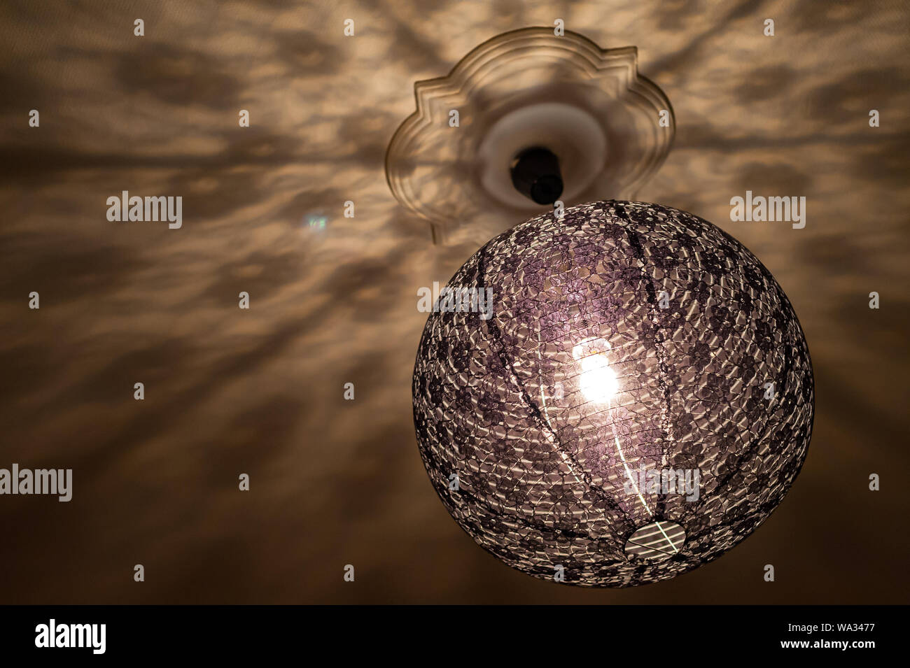 Lamp hanging from the ceiling creating a shadow pattern Stock Photo - Alamy