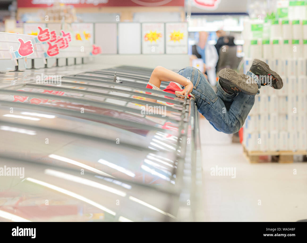 A kid diving into at freezer in a grocery store Stock Photo - Alamy