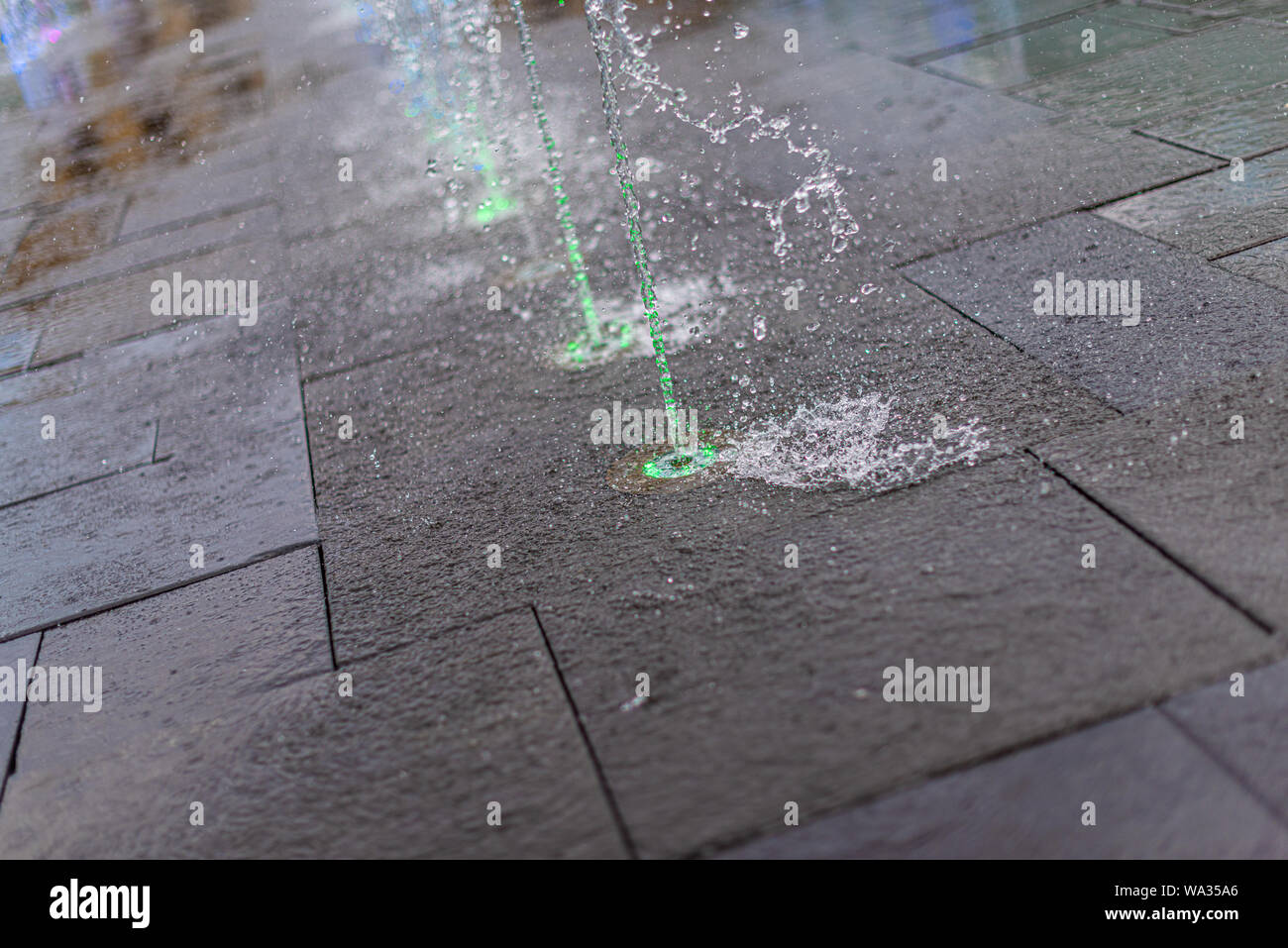 Street water fountain with green lighting Stock Photo - Alamy