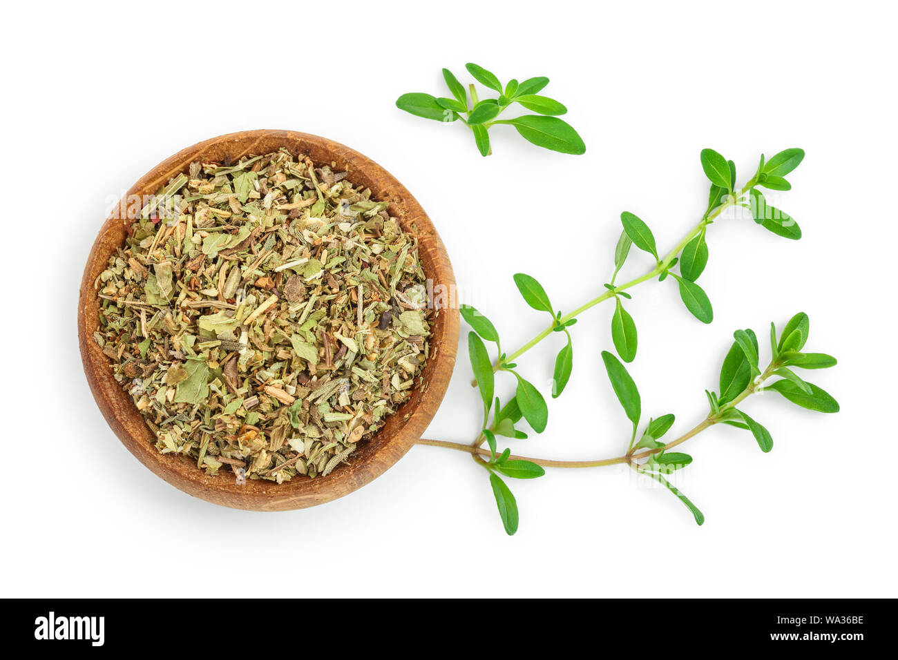 Dried thyme leaves in the wooden bowl, with fresh thyme isolated on white background. Top view ...