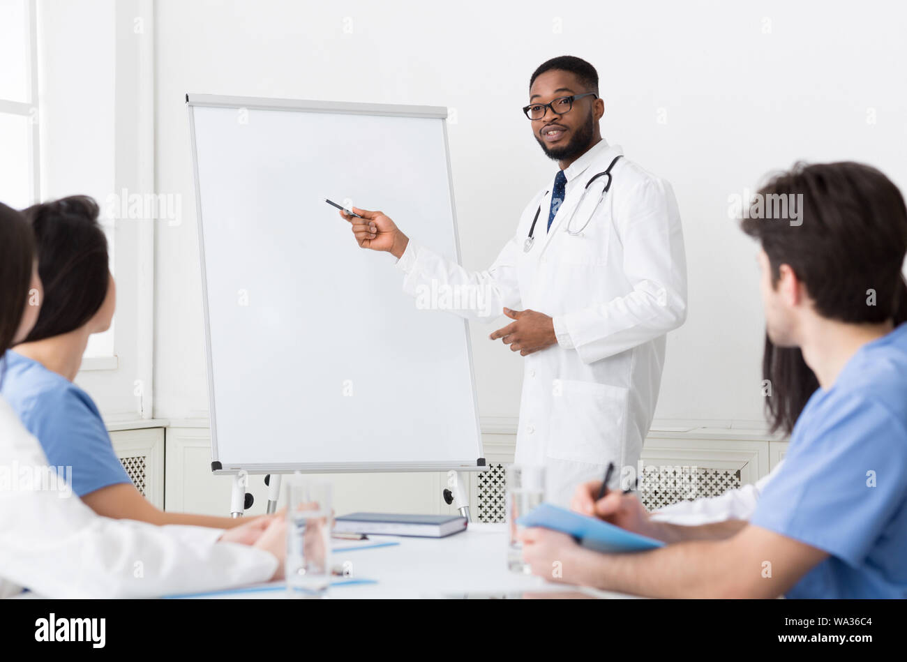 African-american cardiologist giving lecture for interns in clinic ...