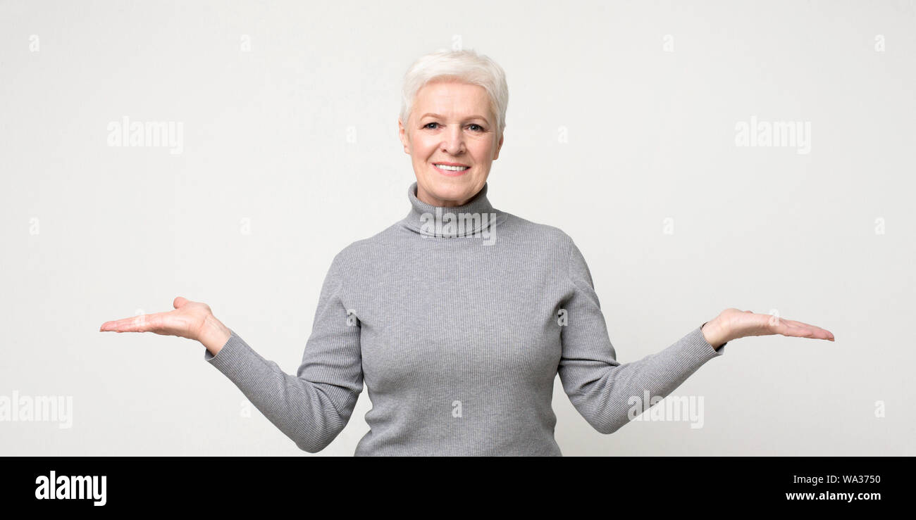 Mature woman comparing variants, making scales with her empty arms ...