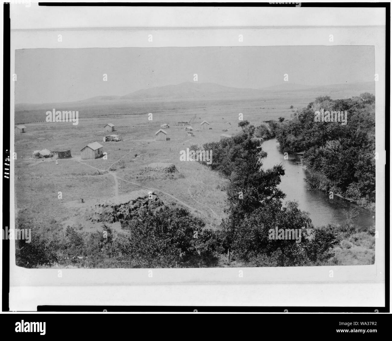 Bird's-eye view of rural buildings and creek or river, in Indian ...