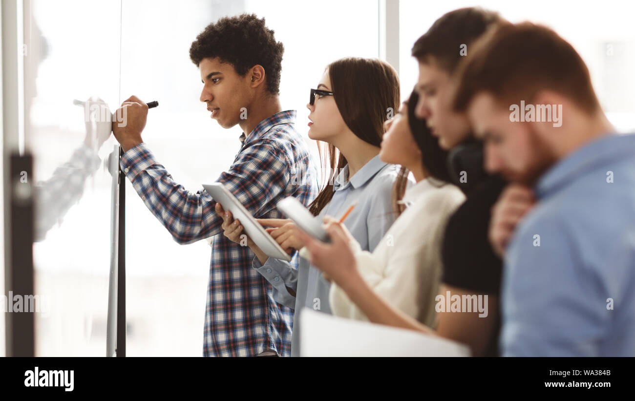 Student boy writing answers to tasks on whiteboard in class Stock Photo ...