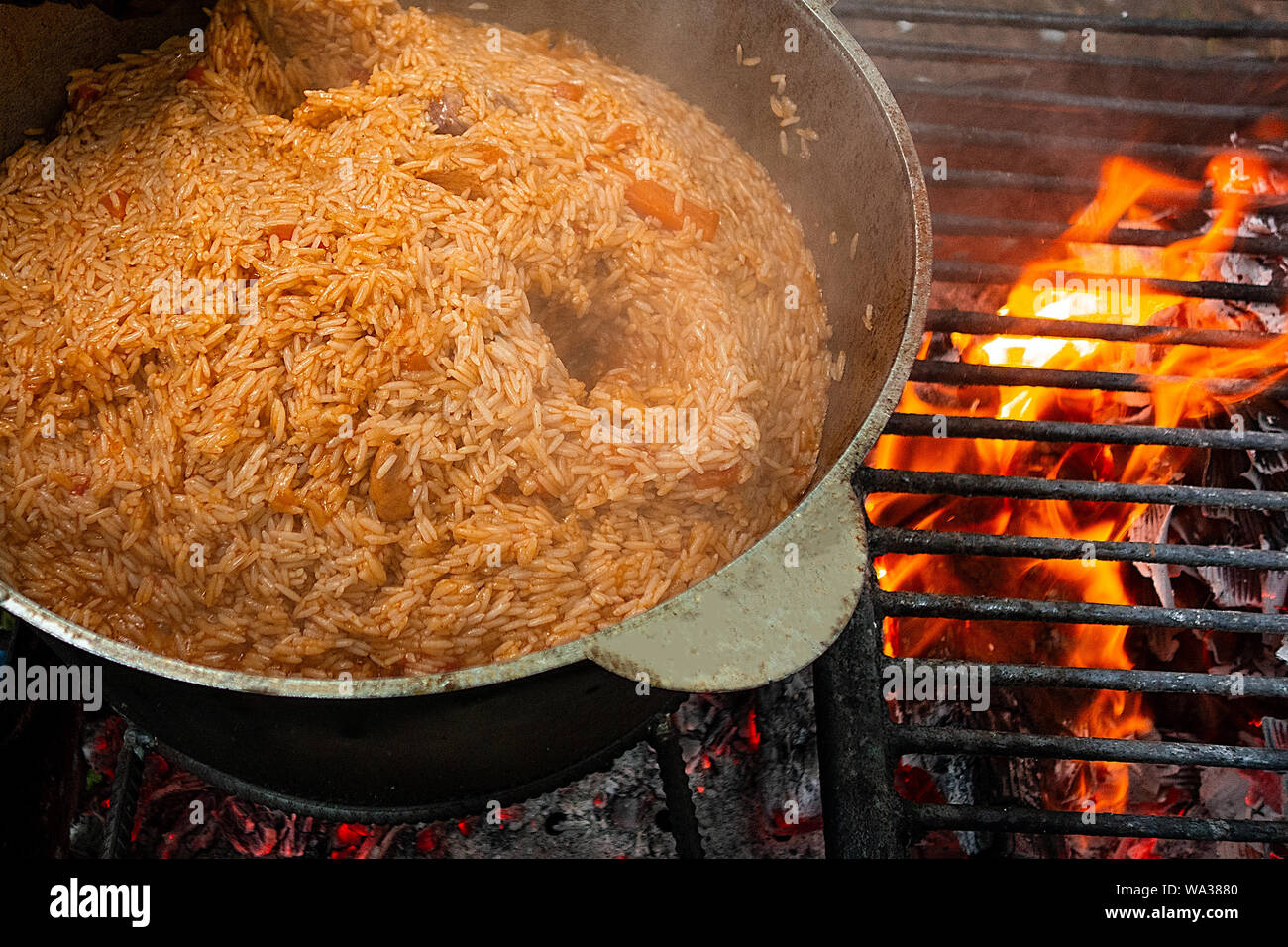 Pilaf cooking on fire outdoor. Open air kitchen at party picnic. Big ...