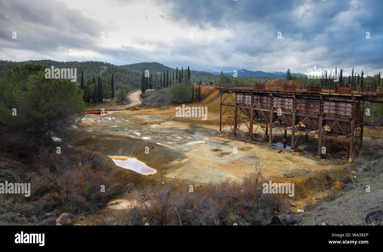 Abandoned copper mine with red toxic water and dramatic stormy cloudy ...