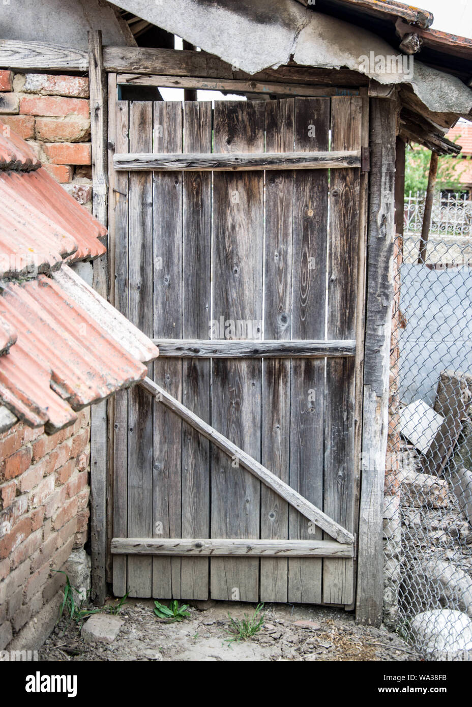 Old rustic wooden door in the backyard, broken door, open or closed ...