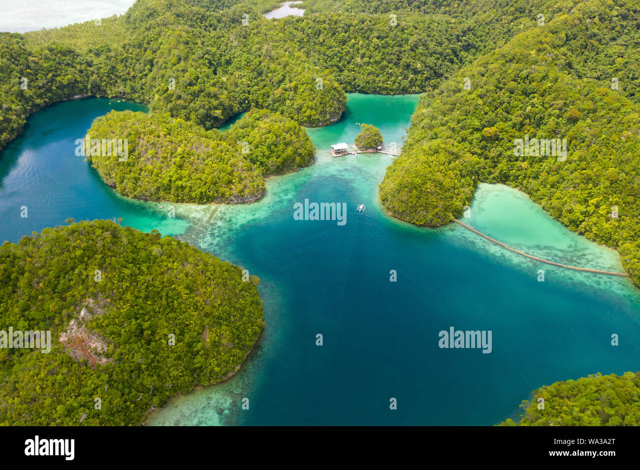 Cove and blue lagoon among small islands covered with rainforest. Sugba ...