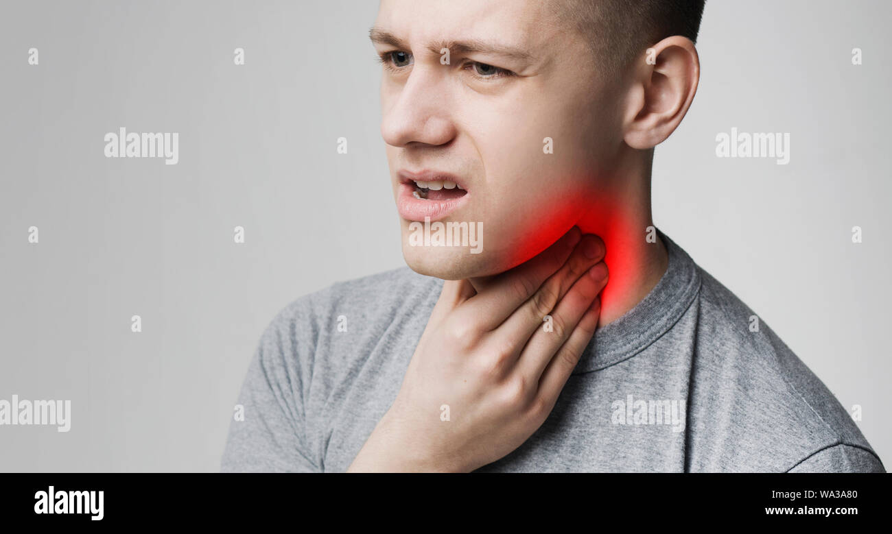 Young man suffering from tonsillitis, pulping his neck Stock Photo - Alamy
