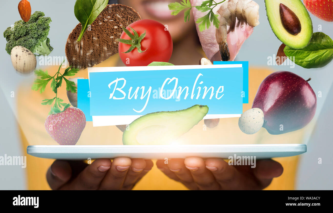woman holding tablet with flying fruits and vegetables Stock Photo - Alamy