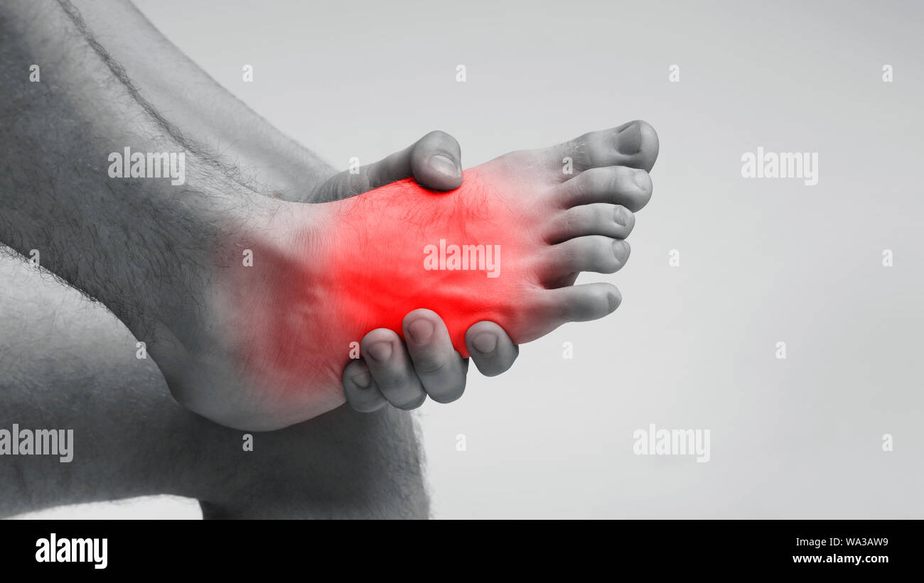 Man holding his painful foot, cramp, muscular spasm Stock Photo - Alamy