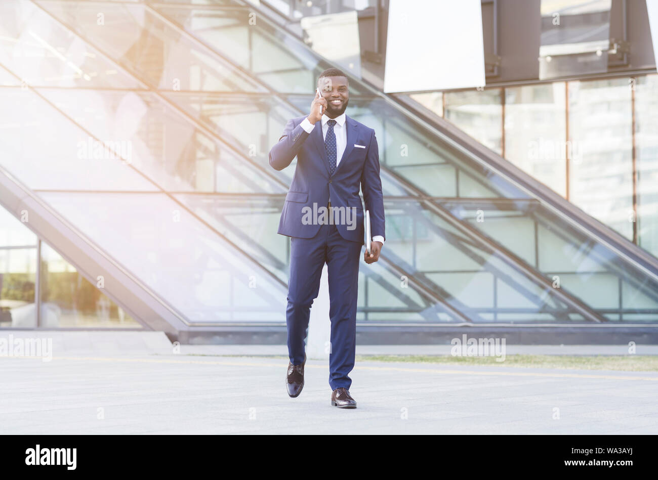 Businessman talking on phone walking hi-res stock photography and ...