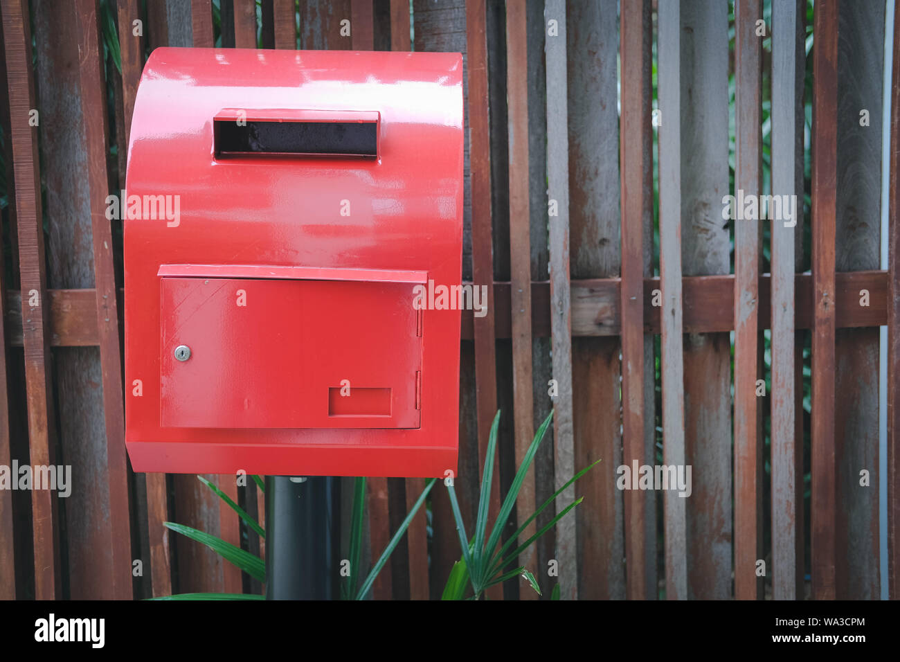 red post box mailbox beside wooden fence Stock Photo - Alamy