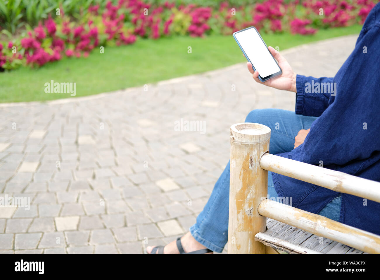Woman sitting on bench using hi-res stock photography and images - Alamy