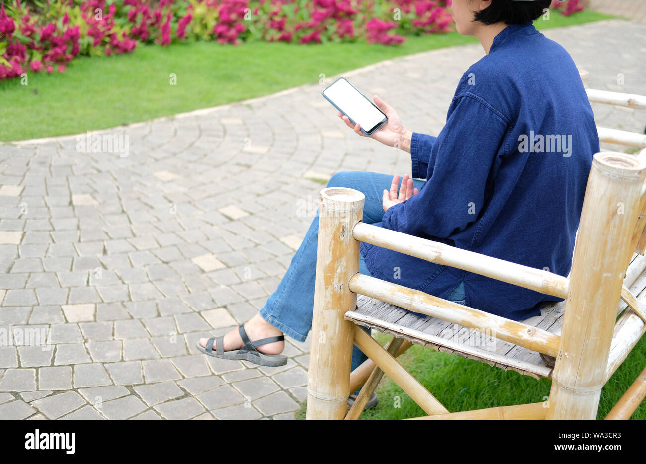 Woman sitting on bench using hi-res stock photography and images - Alamy