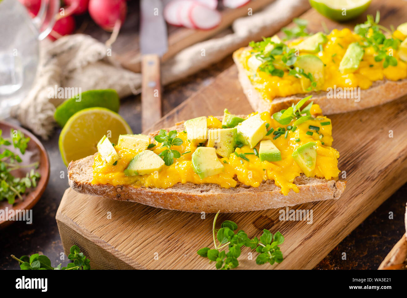 Bio scrambled eggs on rustic french baguette with fresh herbs and ...