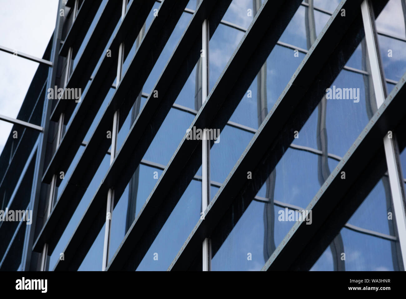 Diagonal view of new glass office building Stock Photo - Alamy