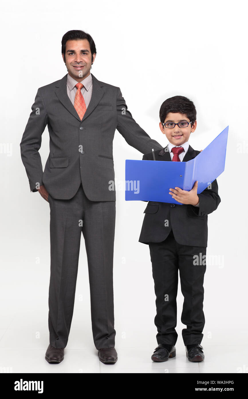 Boy imitating as a businessman and standing with his father Stock Photo ...