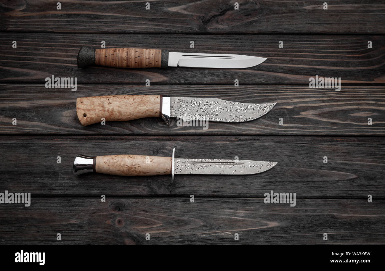 Hunting bowie knife with a wooden handle on dark wooden background ...