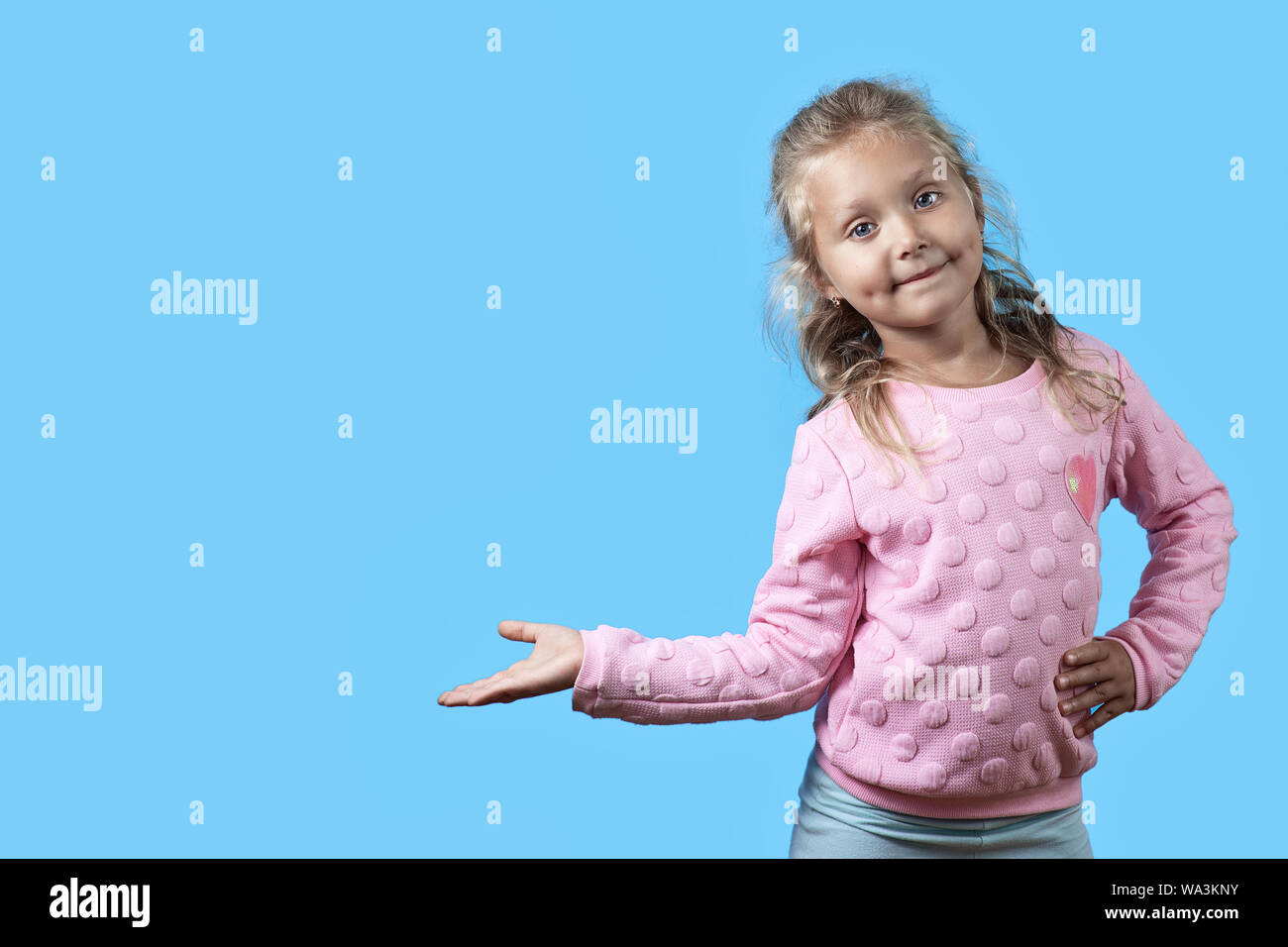 A cute cheerful girl with dimples on her cheeks and curly hair smiles ...